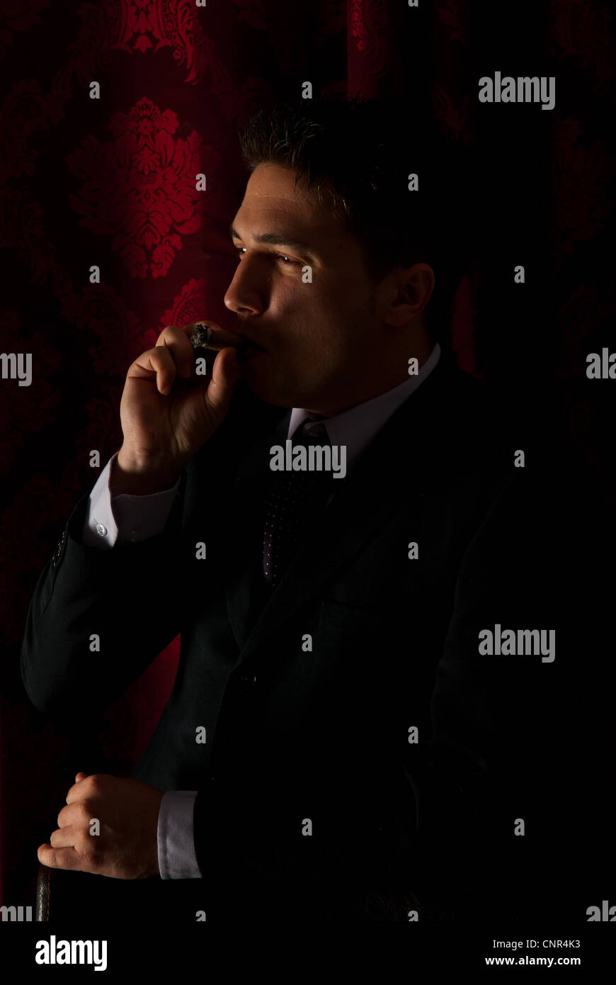 Profile of elegant man smoking in night and looking to the light Stock ...