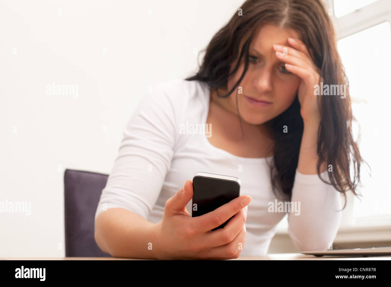 Portrait of an upset woman reading a text message on her phone Stock ...