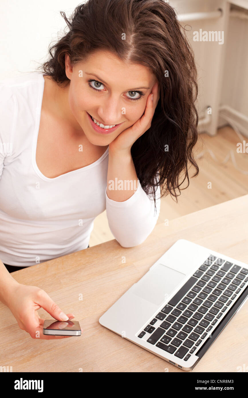 Portrait of a smiling woman texting on her cellphone Stock Photo - Alamy