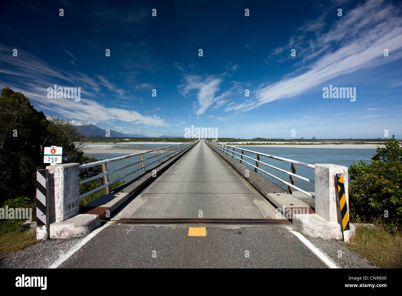 Bridge stretching over rural river Stock Photo - Alamy