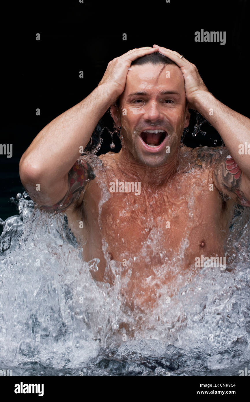 Man splashing in swimming pool Stock Photo - Alamy