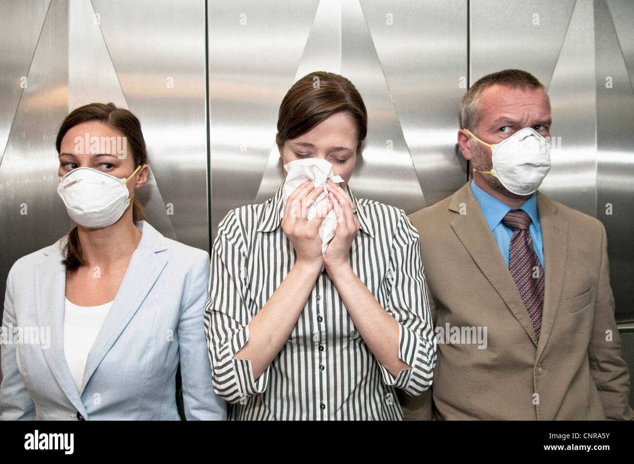 Woman coughing around others in elevator Stock Photo - Alamy