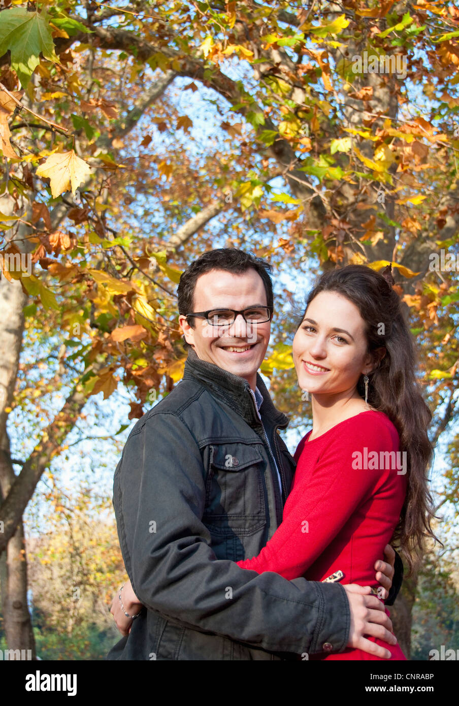Couple smiling under fall leaves Stock Photo - Alamy