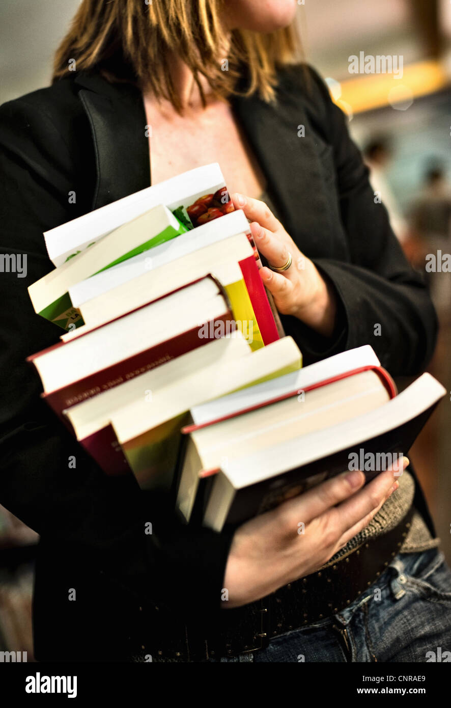 Woman carrying stack of books Stock Photo - Alamy