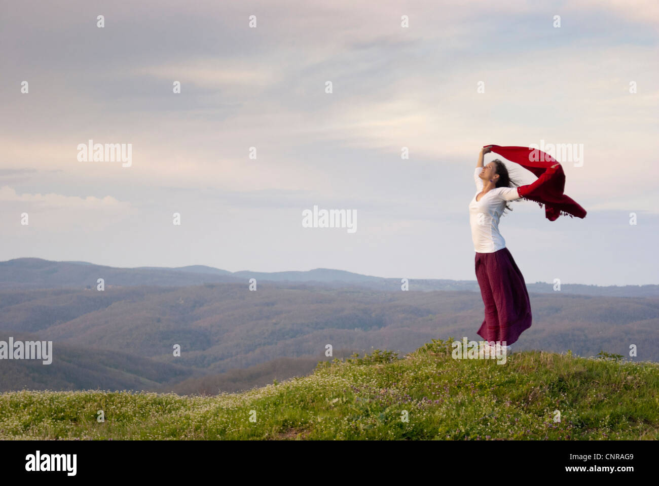 Beautiful young woman standing on top of mountain feeling empowered ...