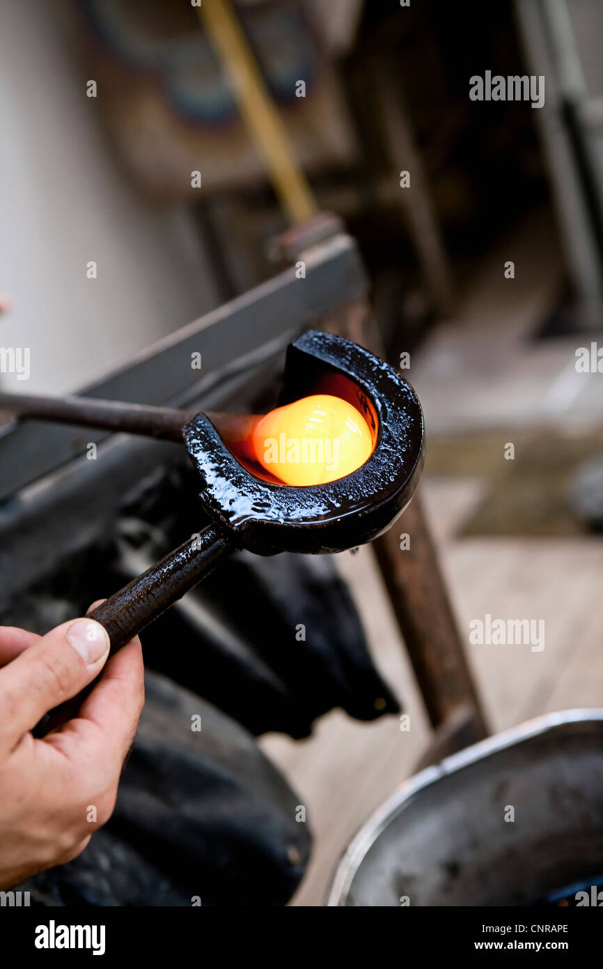 Glassblower shaping hot glass Stock Photo - Alamy
