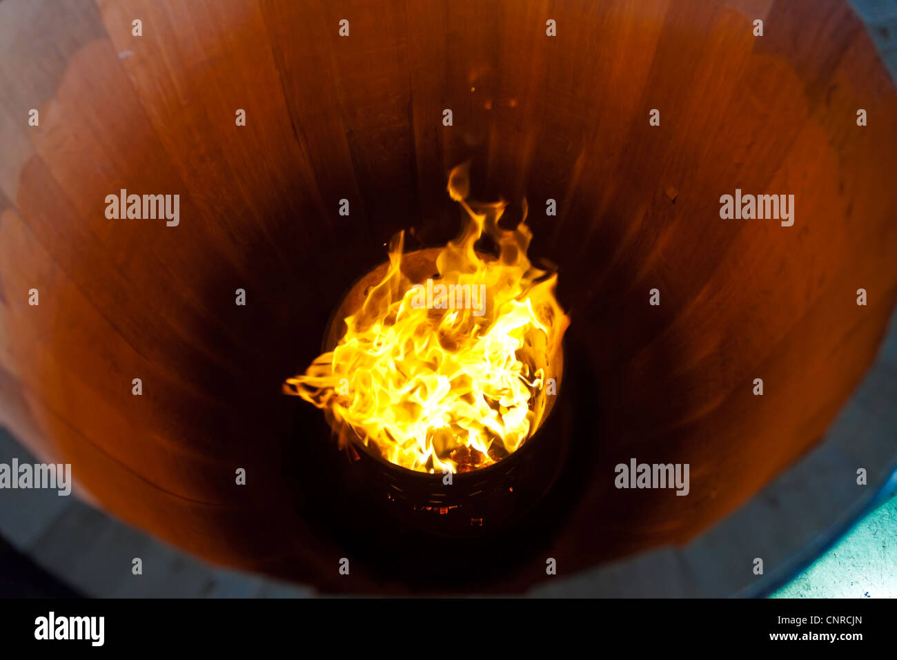 Flames of the brazier inside a barrel., The staves are then heated ...