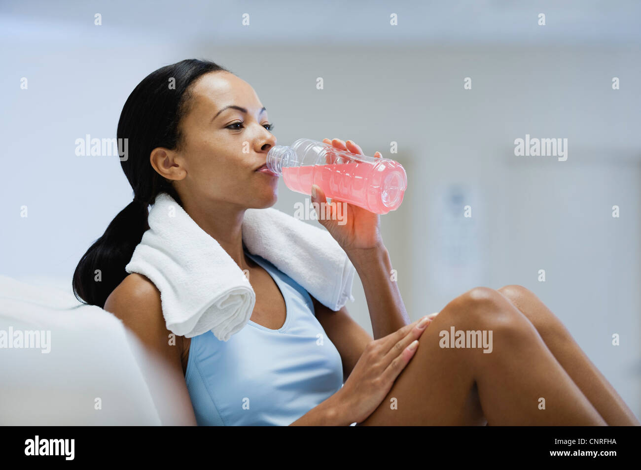 Young woman drinking sports drink Stock Photo - Alamy