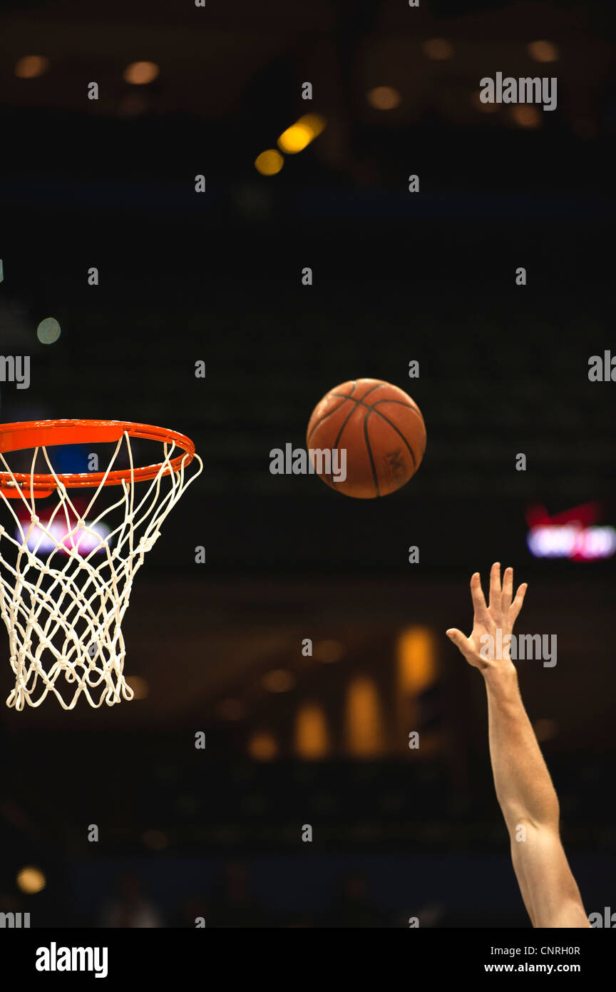 Basketball player throwing ball toward basketball hoop, cropped Stock ...
