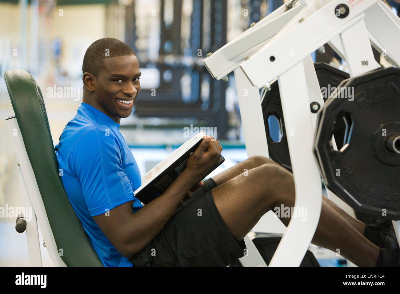Young man lifting leg weights, portrait Stock Photo - Alamy