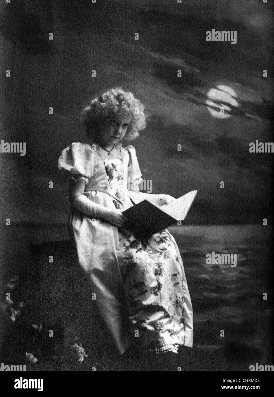 people, children, girl sitting on rock and reading a book, studio shot ...