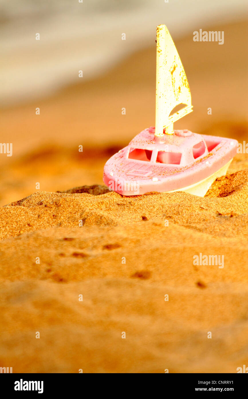 toy boat stuck on the beach Stock Photo - Alamy