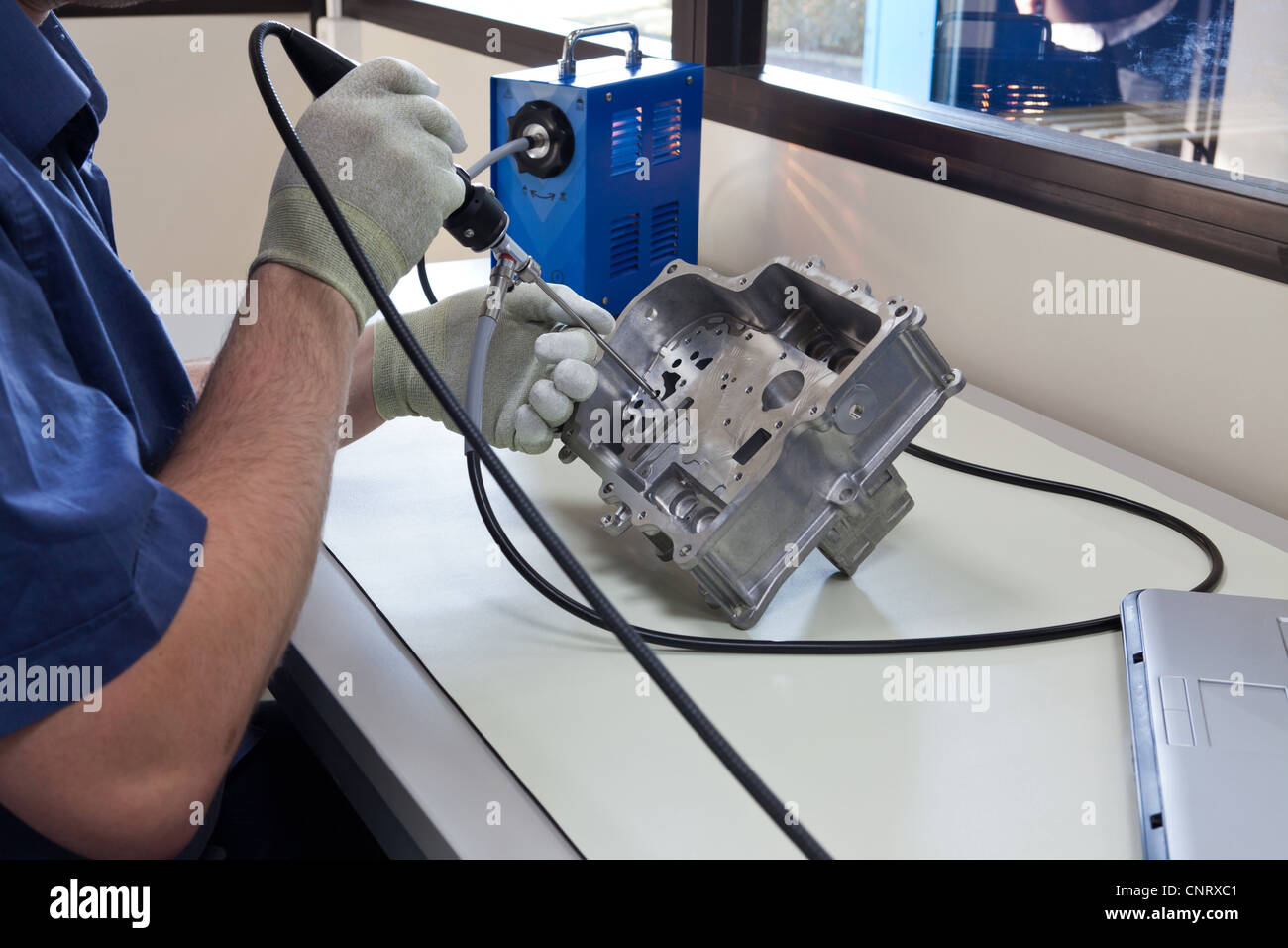 Video endoscopy. An employee checks a part of a gear case with the ...