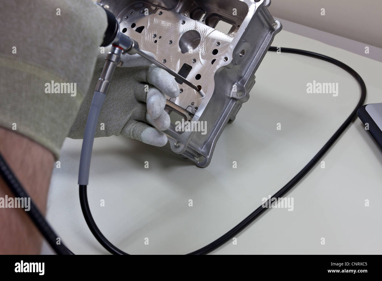 Video endoscopy. An employee checks a part of a gear case with the ...