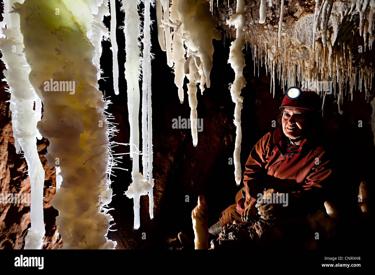 Woman caver looking at stalactites in a French cave France Stock Photo ...