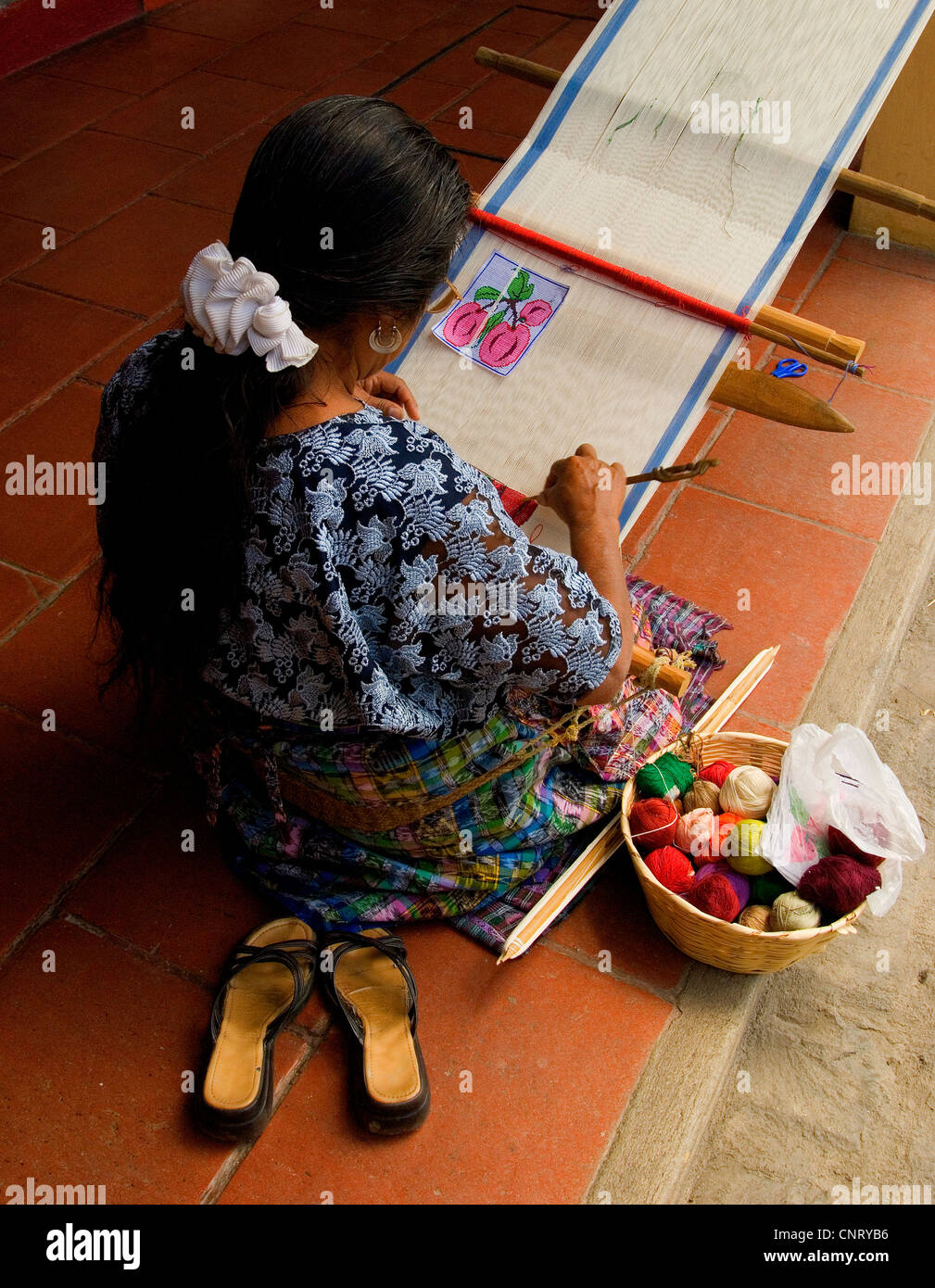 A weaver uses a traditional backstrap loom to create Guatemala's ...