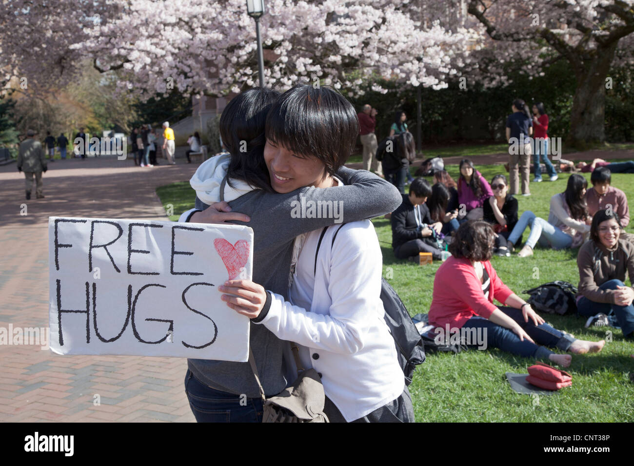 Young man offering hugs, University of Washington campus in spring time ...