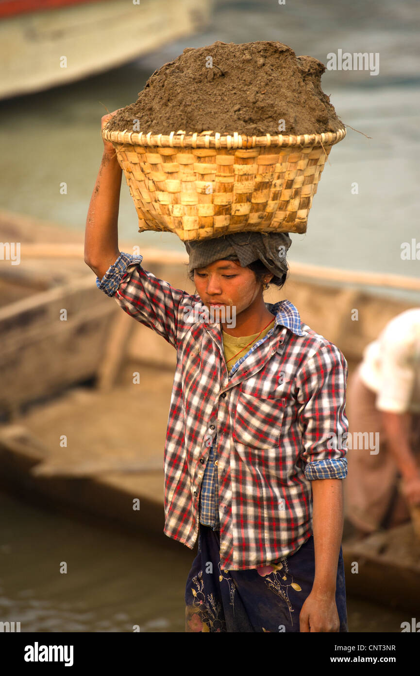 Woman carrying sand dredged from the Irrawaddy River in Mandalay ...
