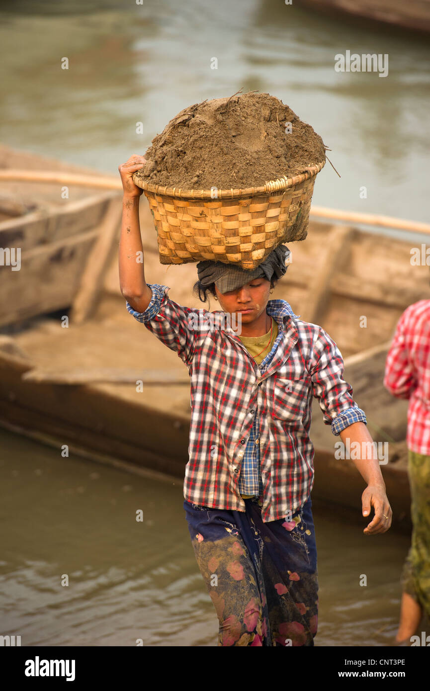 Woman carrying sand dredged from the Irrawaddy River in Mandalay ...