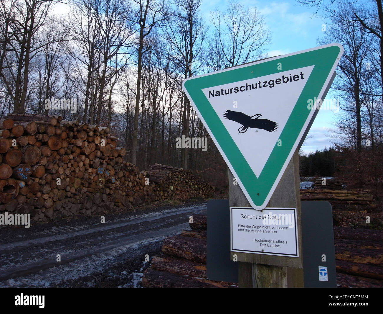 pile of logs in winter and sign nature reserve, Naturschutzgebiet ...