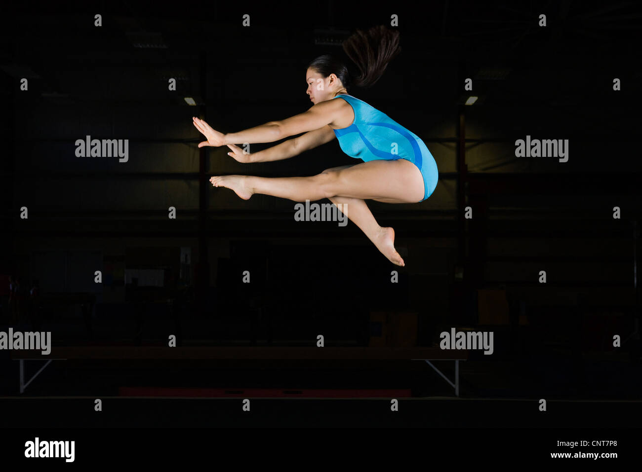 Teenage girl gymnast jumping on balance beam Stock Photo - Alamy