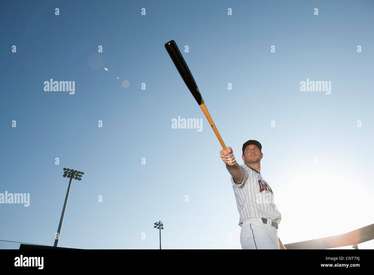 Baseball player holding out baseball bat Stock Photo - Alamy