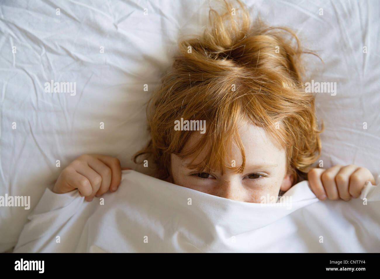 Boy covering face with bed sheet, directly above Stock Photo - Alamy