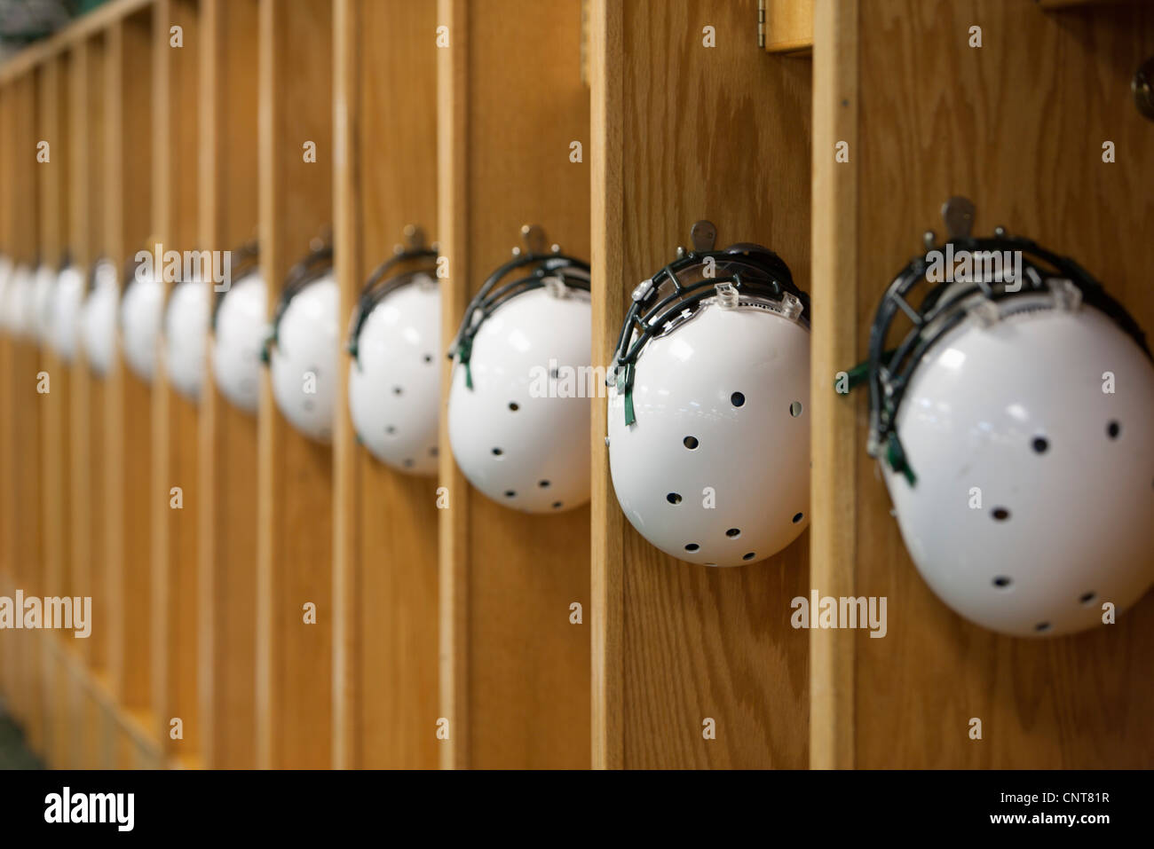 Helmets hanging in locker room Stock Photo - Alamy