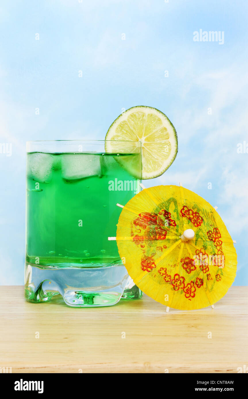 Lime flavored cocktail with a slice of lime and a cocktail umbrella on ...
