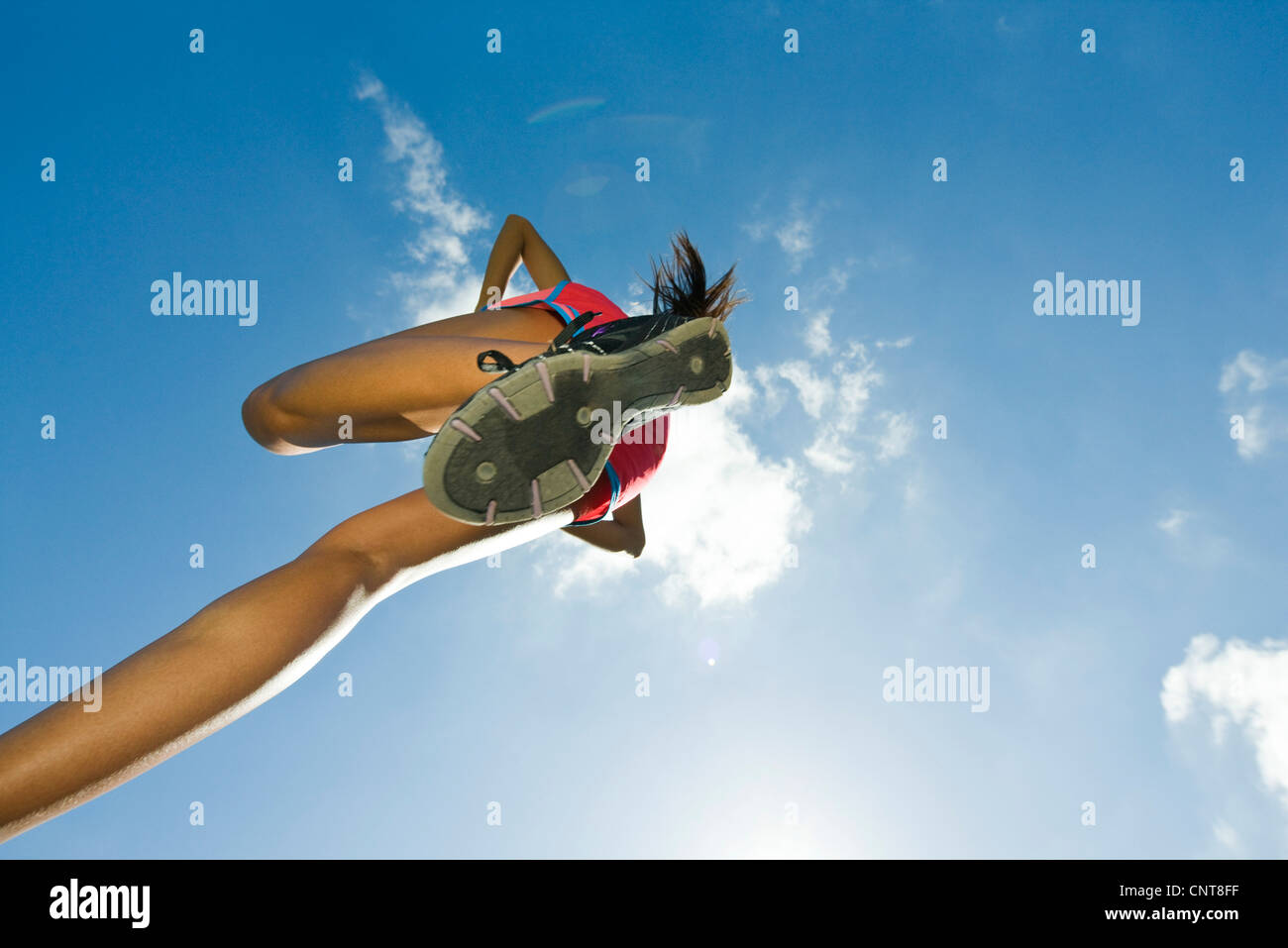 Female athlete jumping in air, directly below Stock Photo - Alamy