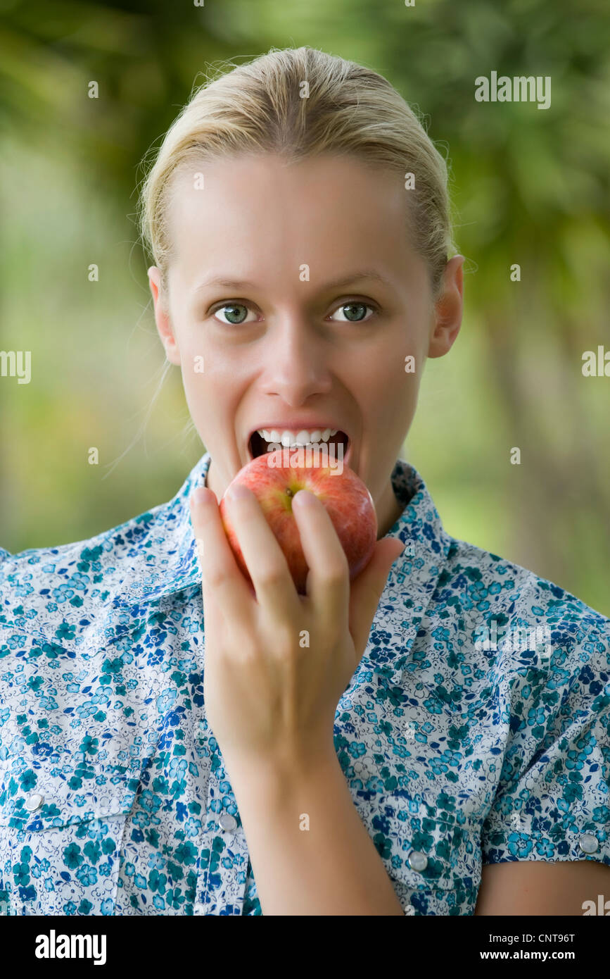 Young woman biting into apple, portrait Stock Photo - Alamy