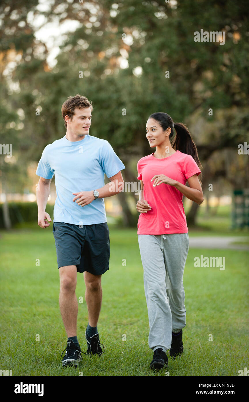 Young couple jogging on grass Stock Photo - Alamy