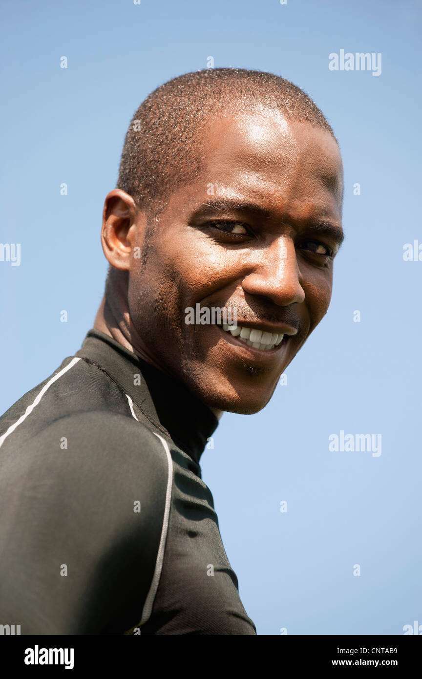 Man smiling over shoulder, portrait Stock Photo - Alamy