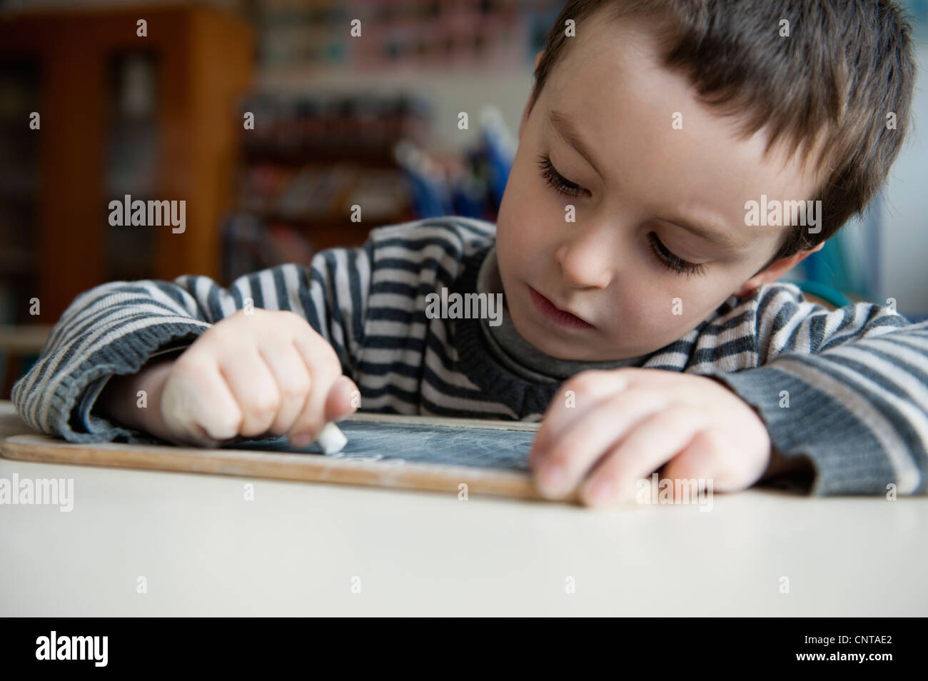 Boy writing on chalkboard Stock Photo - Alamy