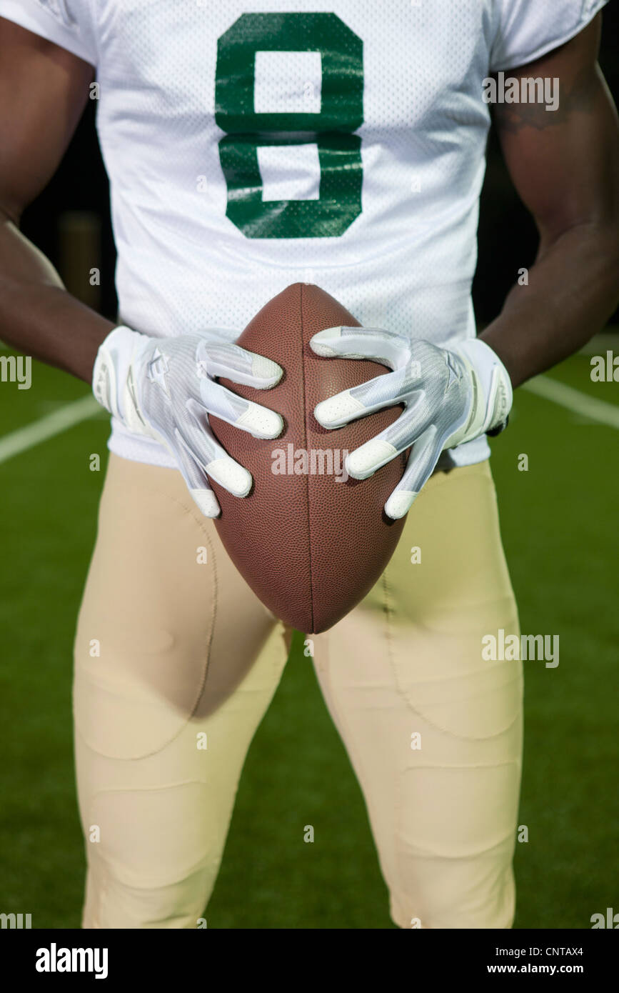 Football player holding football, cropped Stock Photo - Alamy