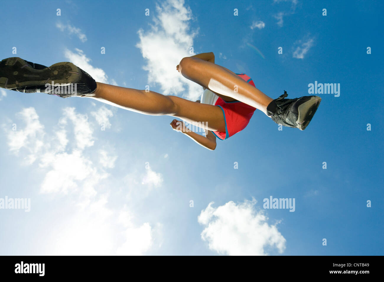 Female athlete jumping in air, directly below Stock Photo - Alamy