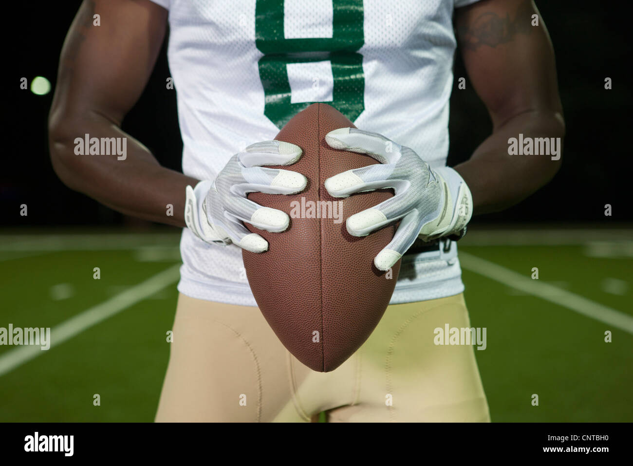 Football player holding football, cropped Stock Photo - Alamy