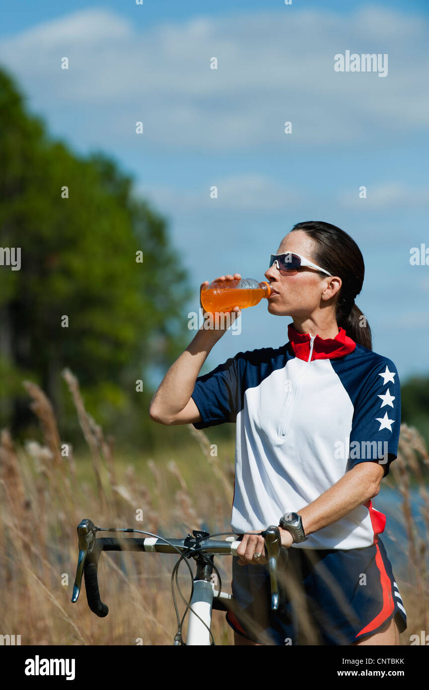 Female cyclist drinking sports drink Stock Photo - Alamy