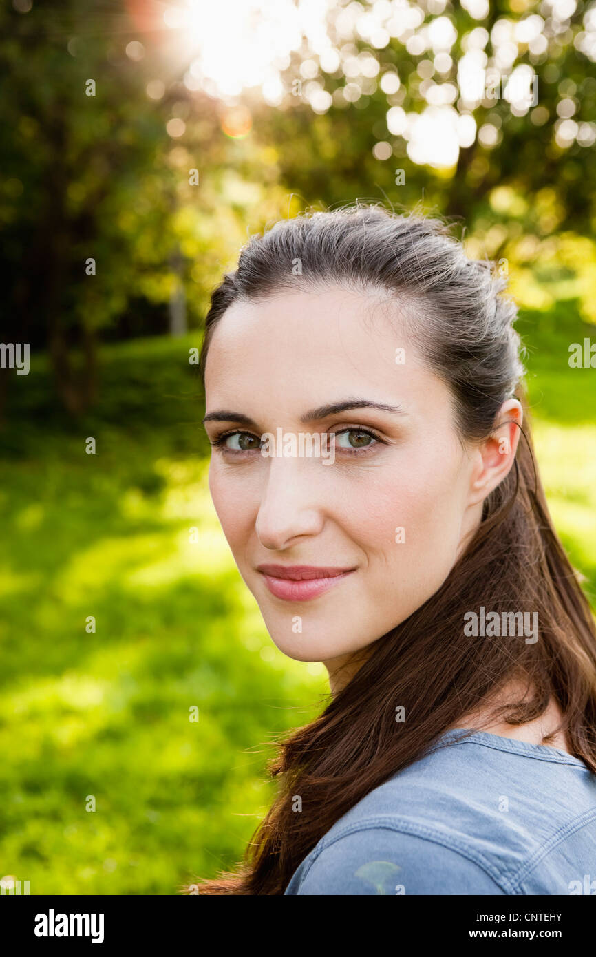 Smiling woman standing in park Stock Photo - Alamy