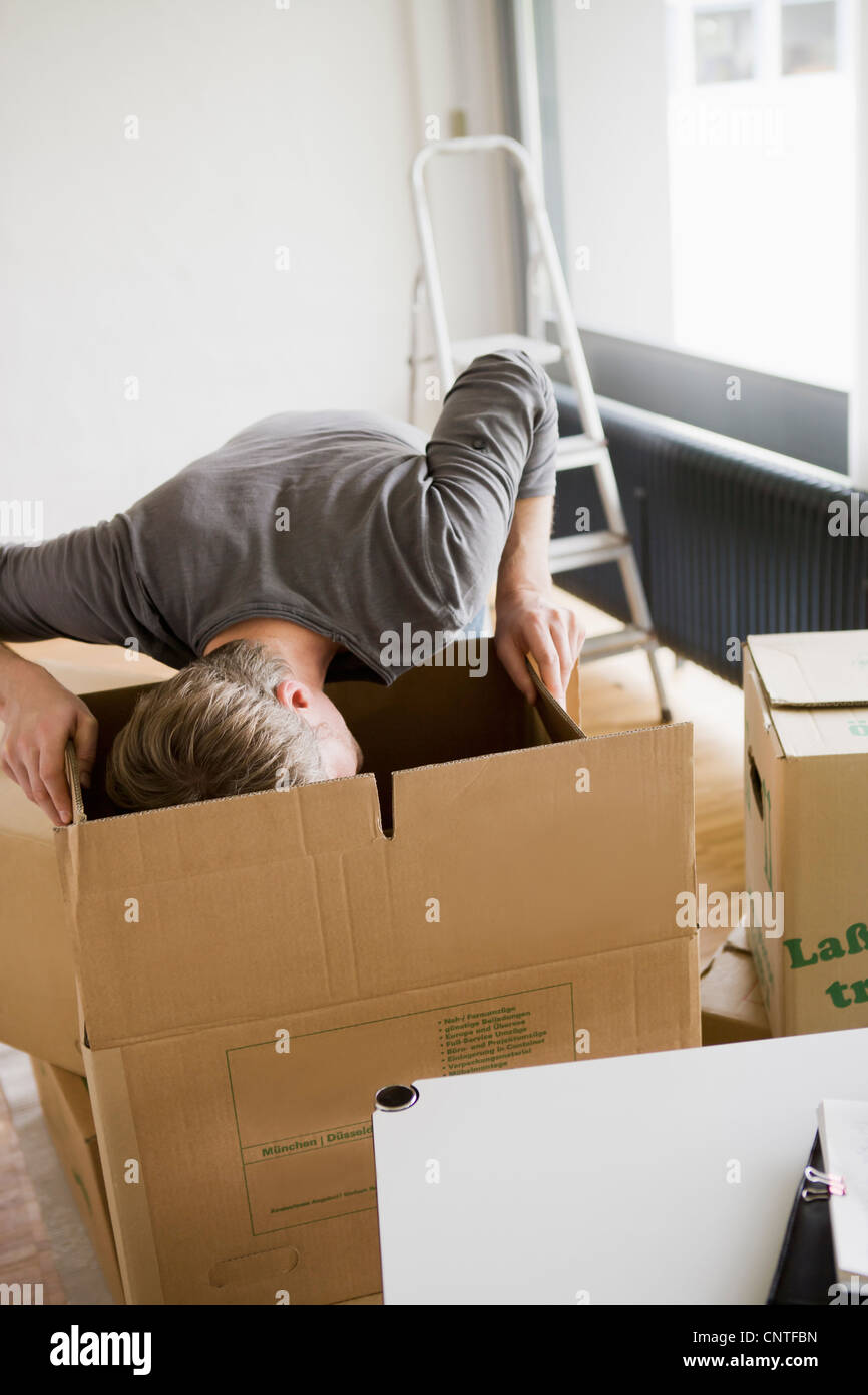 Man searching cardboard boxes Stock Photo - Alamy
