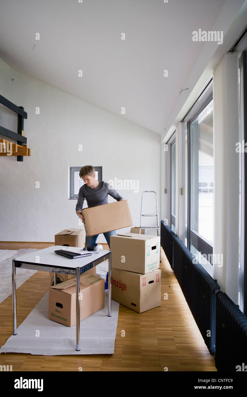 Man stacking cardboard boxes in house Stock Photo - Alamy