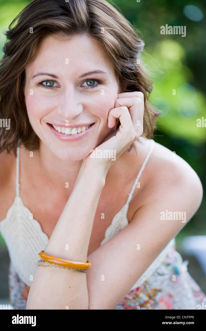 Smiling woman sitting outdoors Stock Photo - Alamy