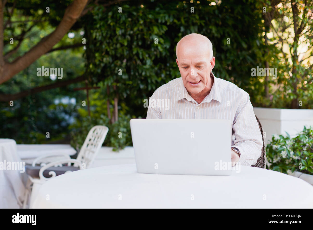 Older man using laptop outdoors Stock Photo - Alamy
