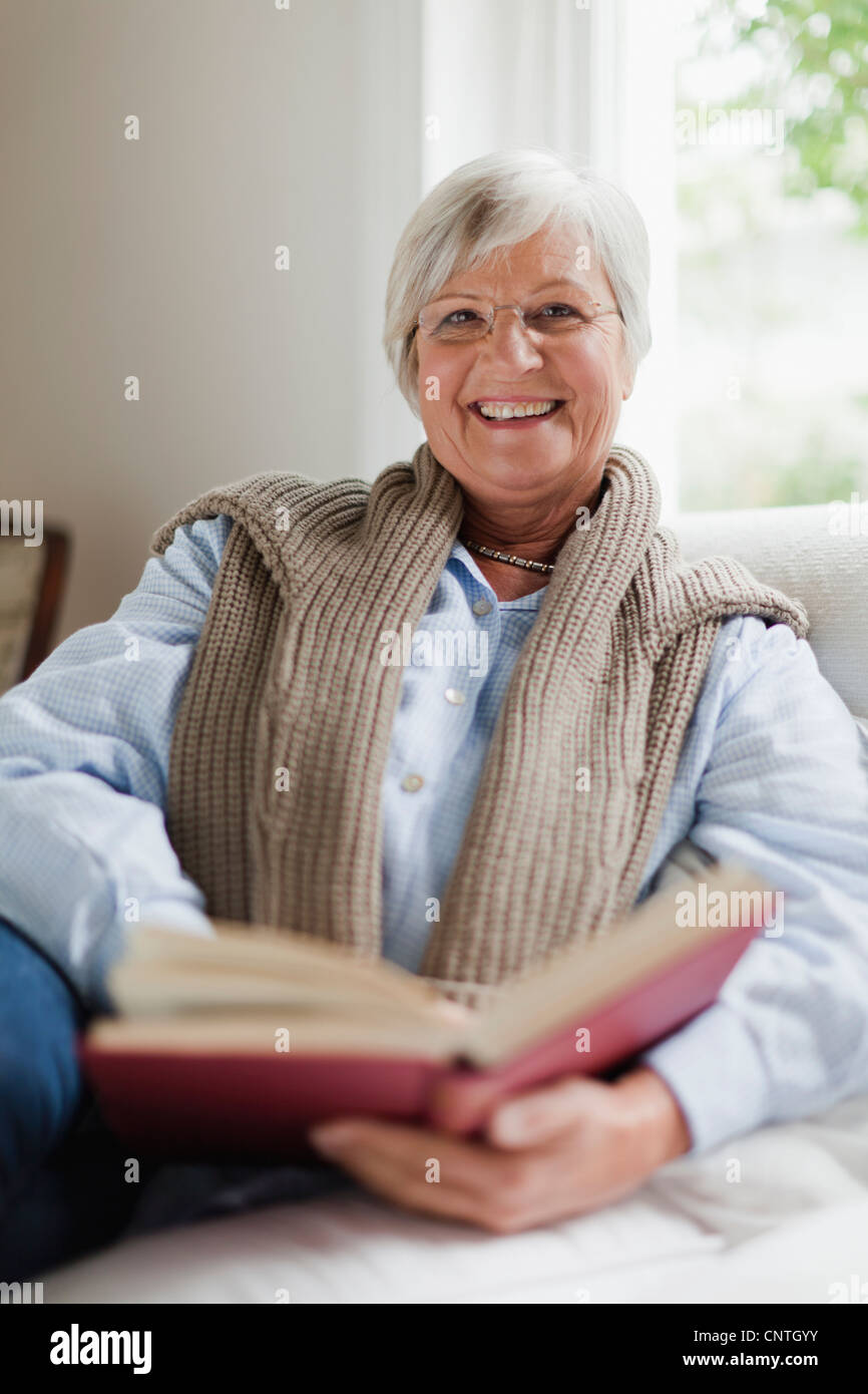 Smiling older woman reading book Stock Photo - Alamy