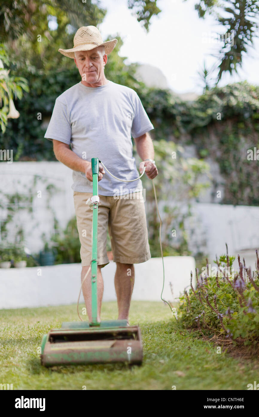 Older man mowing lawn in backyard Stock Photo - Alamy