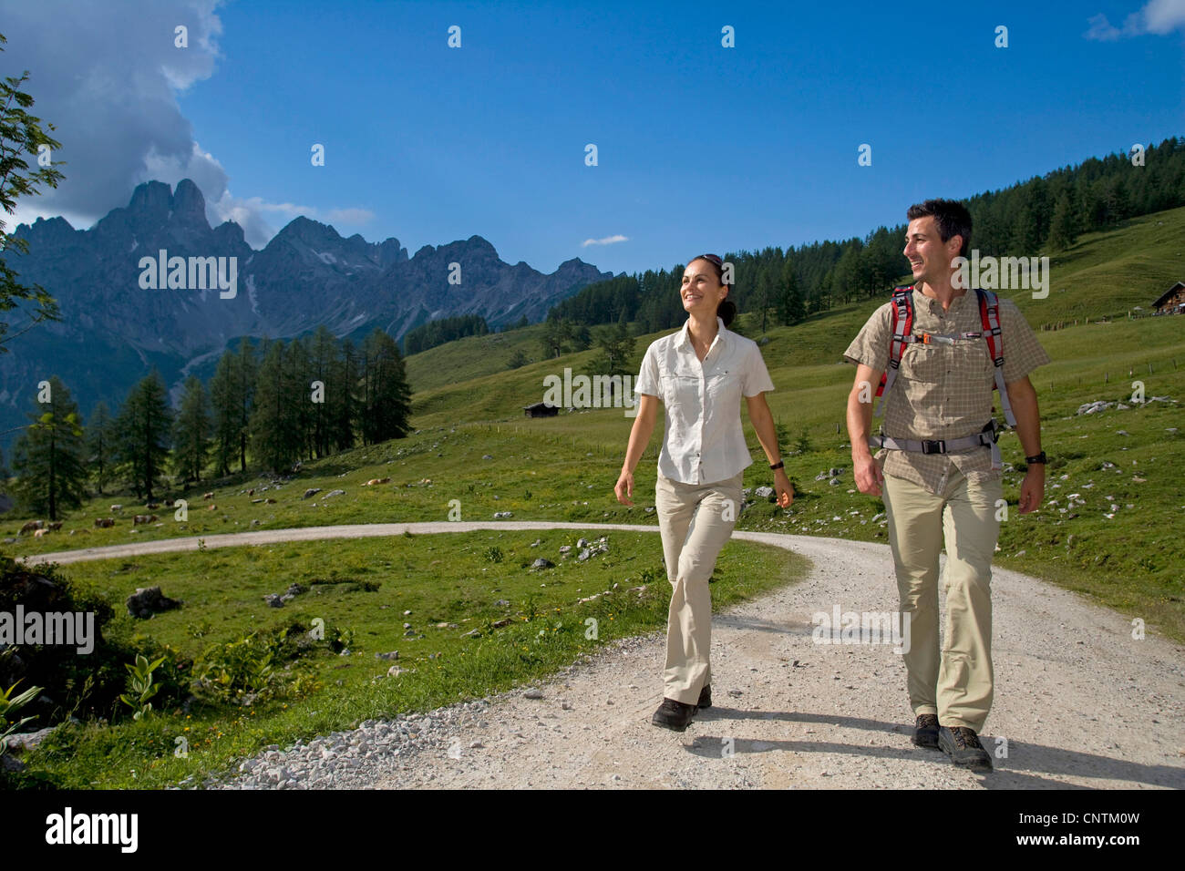 couple wandering in a mountain scenery. Man and woman walking on a path ...