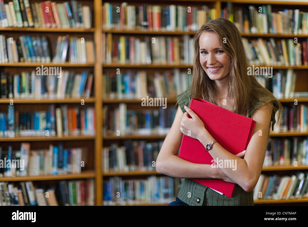 Student carrying binder in library Stock Photo - Alamy
