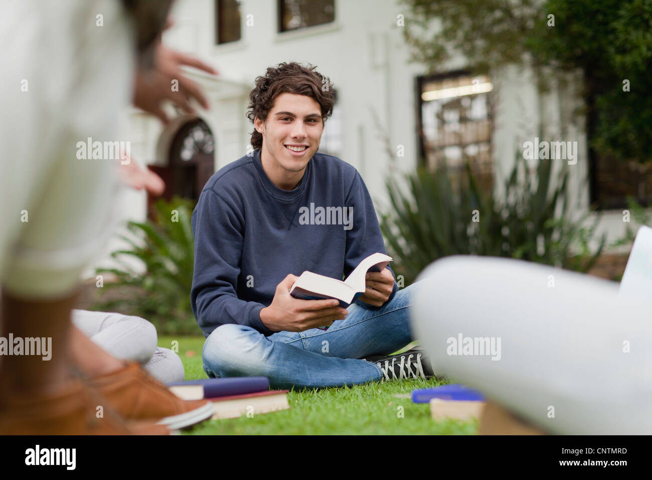 Students studying on grass on campus Stock Photo - Alamy