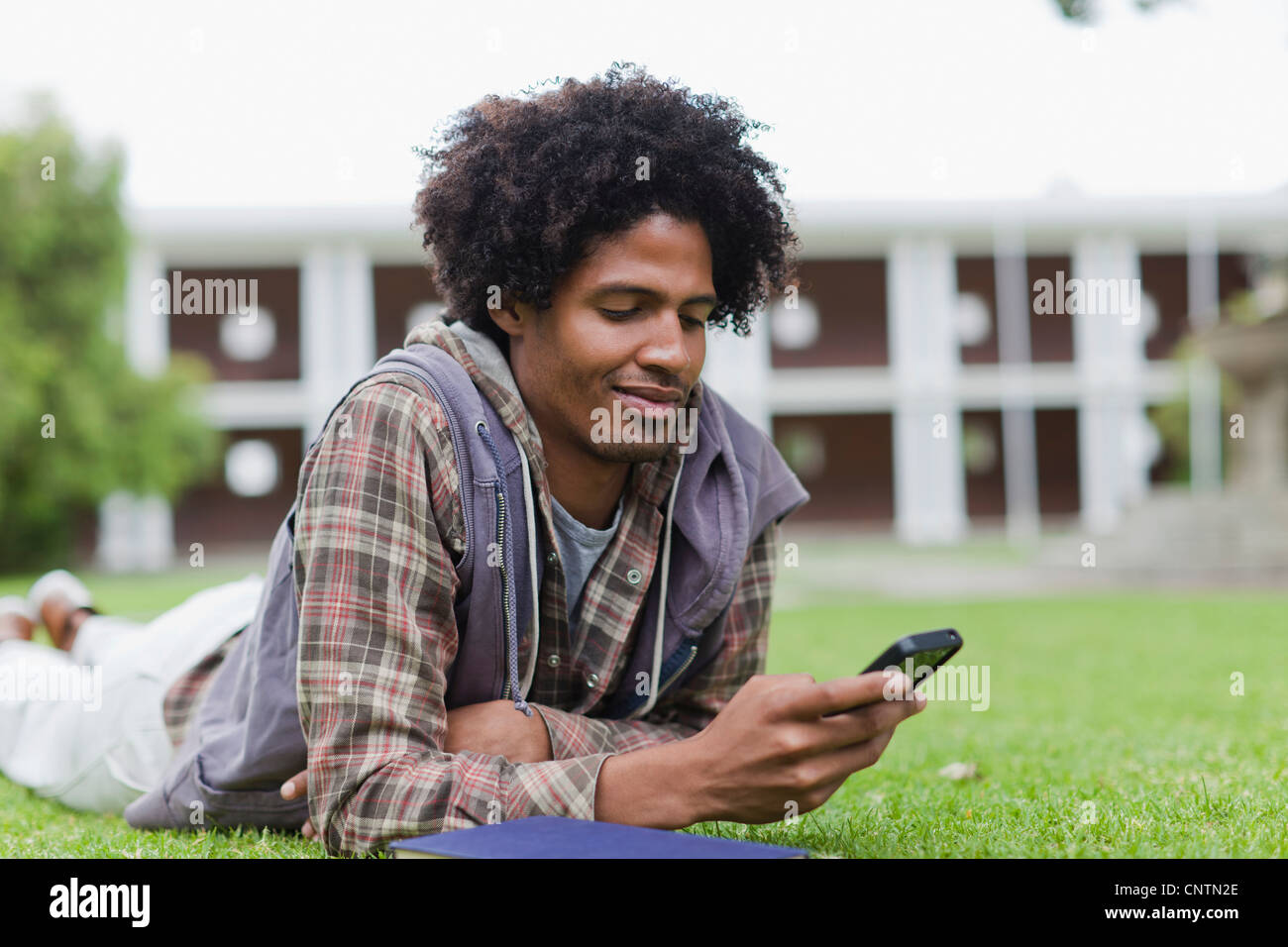 Student using cell phone on grass Stock Photo - Alamy