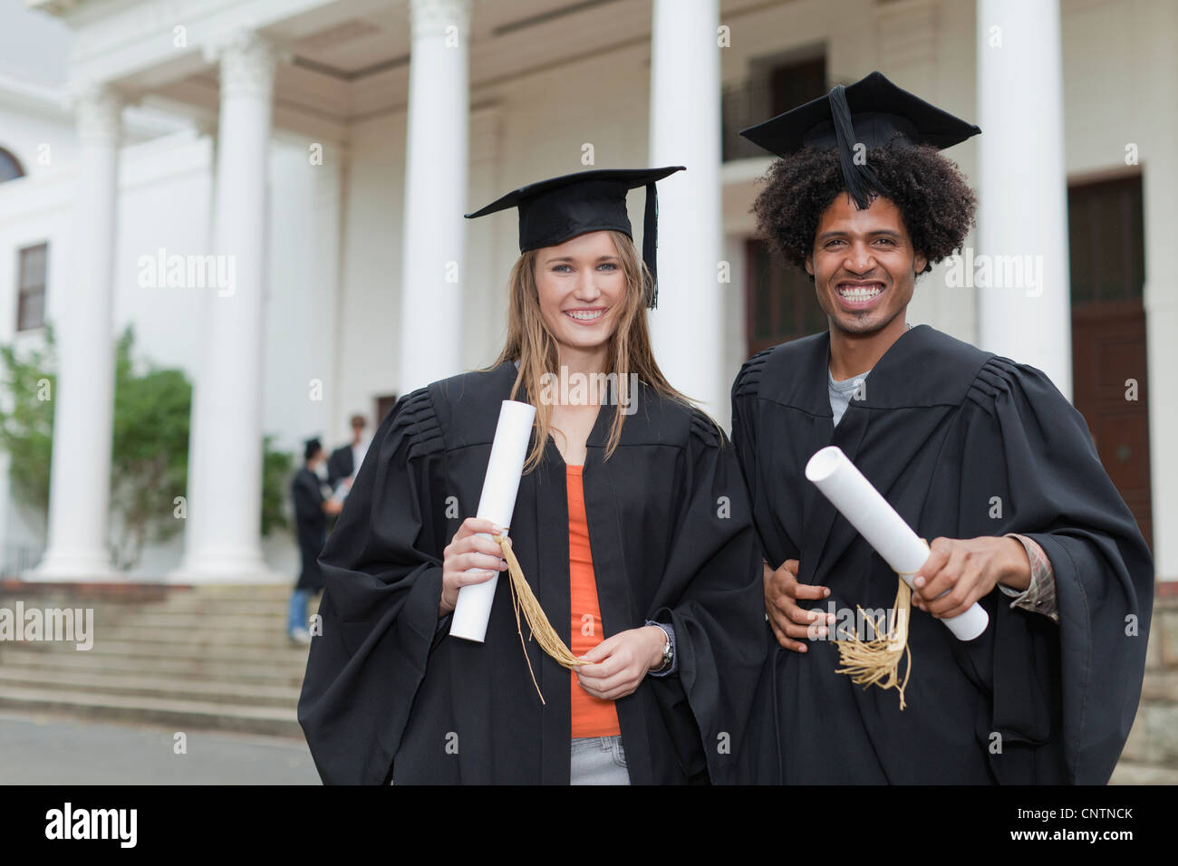 Graduates with their degrees on campus Stock Photo - Alamy
